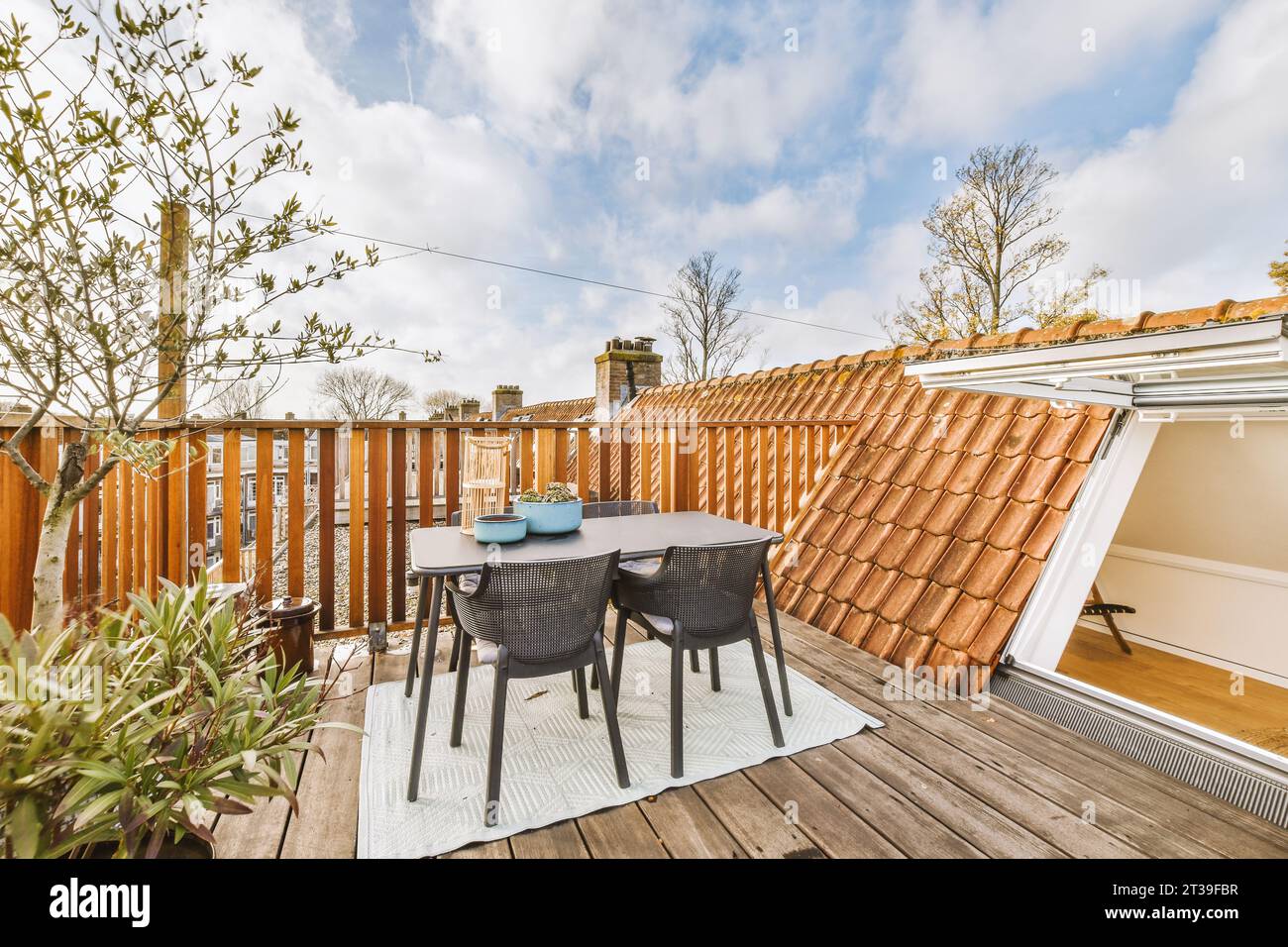 Dining table with chairs arranged by railing in wooden balcony outside ...
