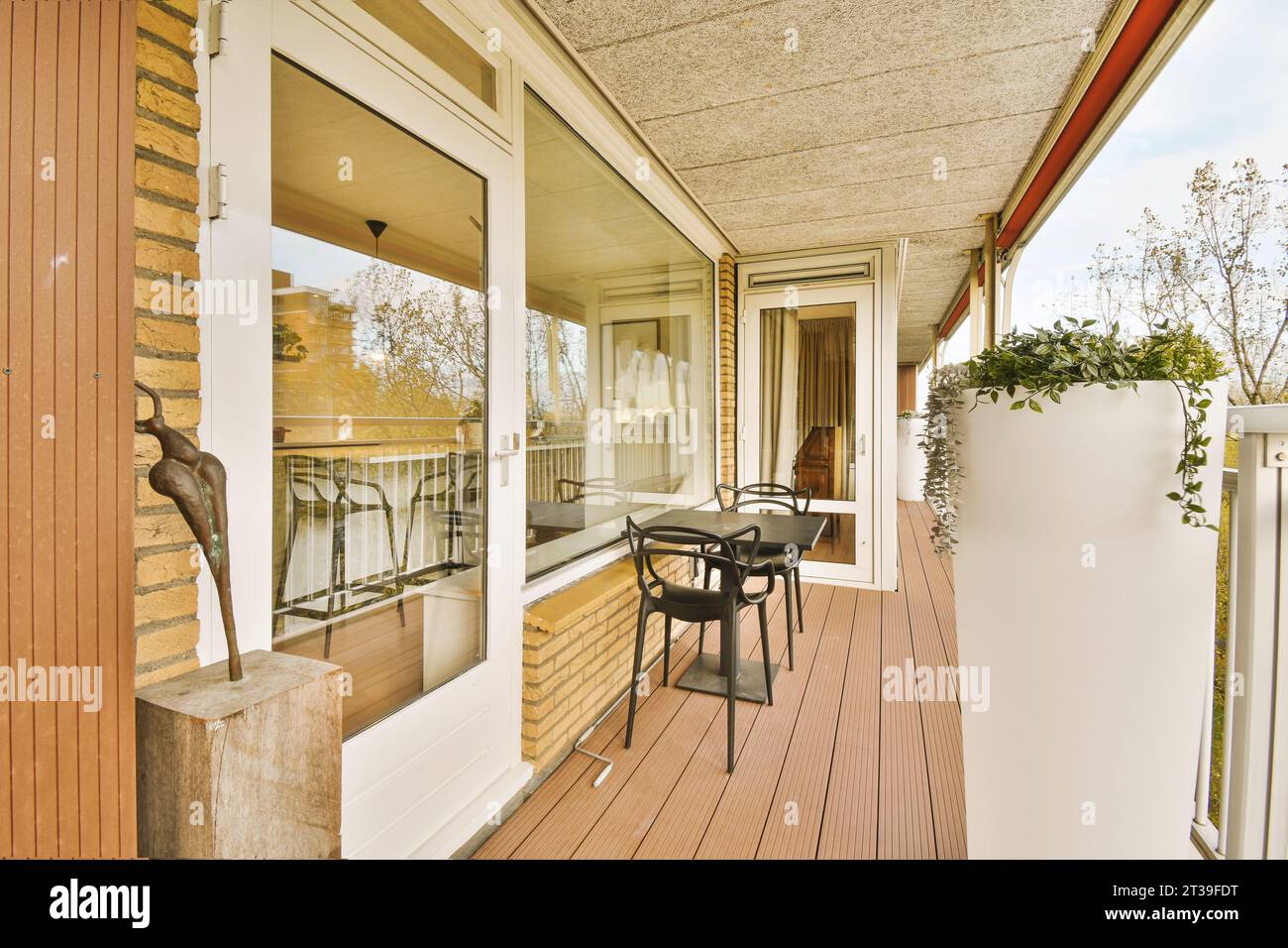 Black table and chairs placed by large window in porch outside ...