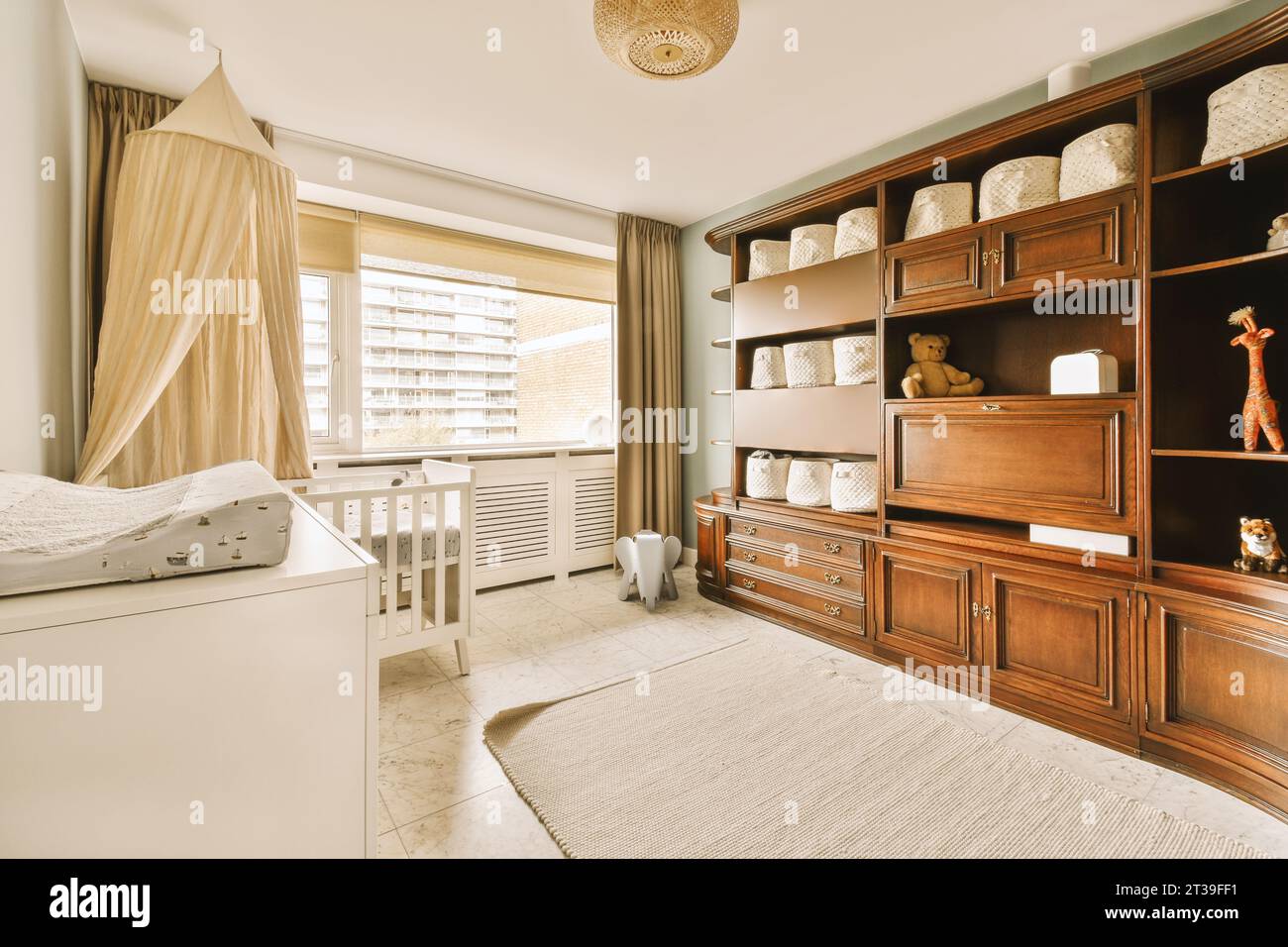 White crib and changing table with wooden shelves next to large window ...
