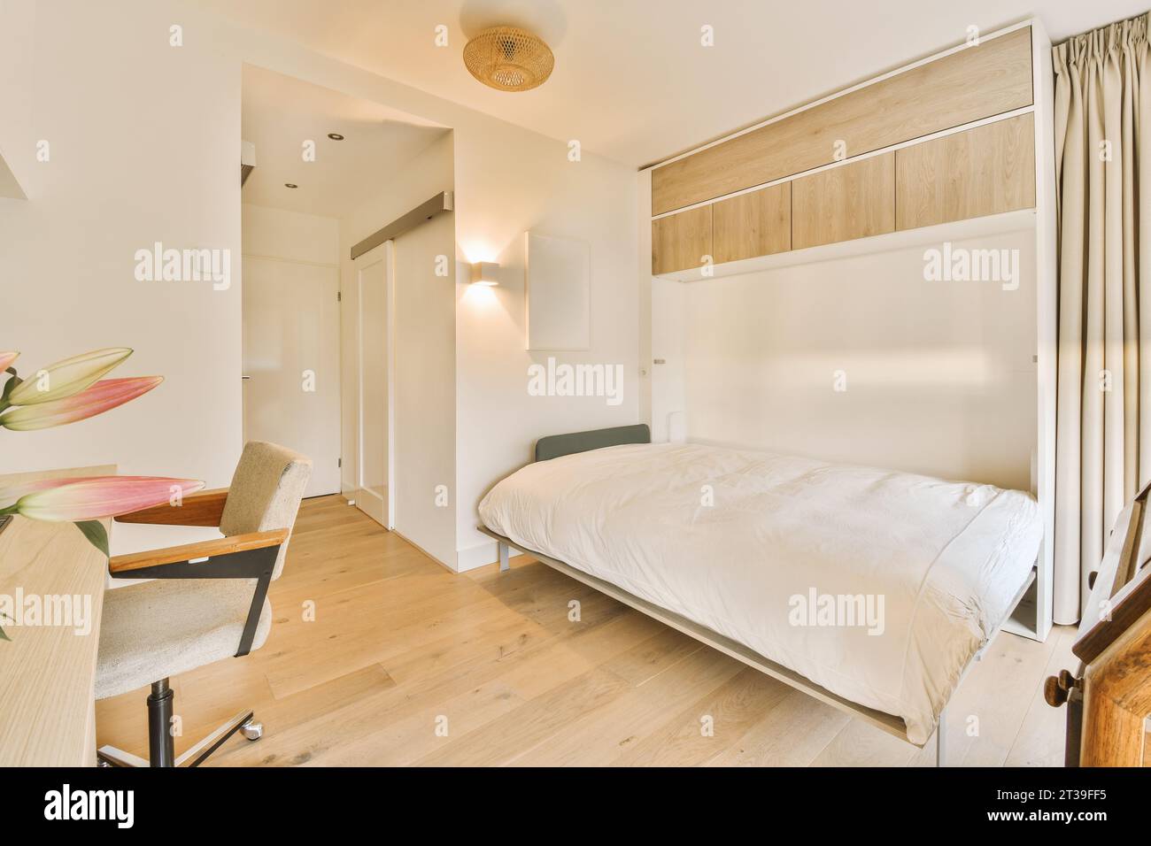 Small comfortable bed with empty chair and desk in bedroom with white ...