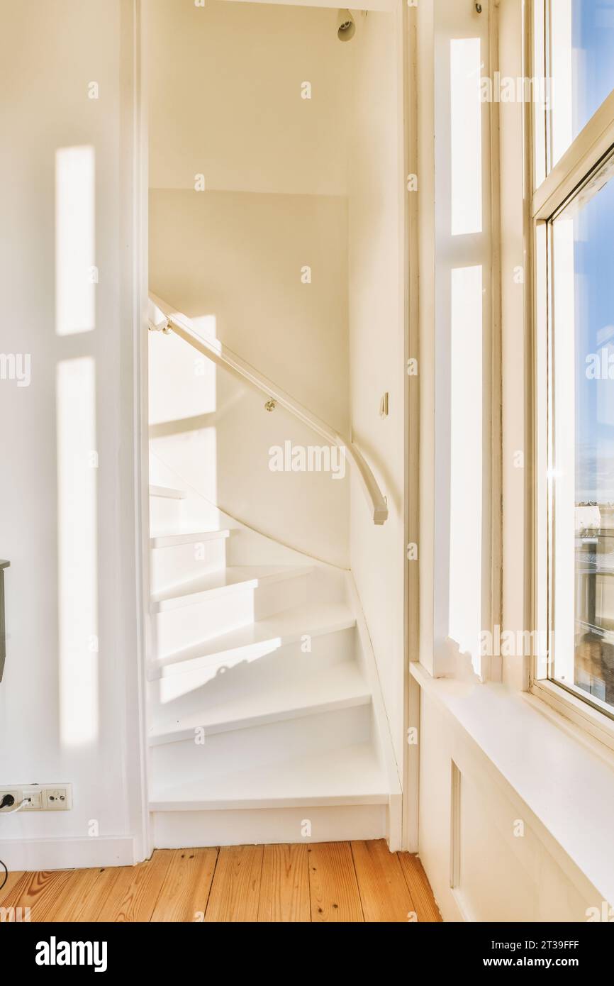 Sunlight falling through window on white stairway leading to upper ...
