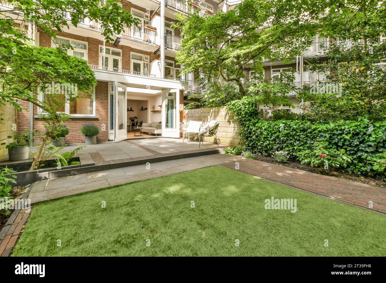 Exterior of modern residential building with tiled patio and grassy ...