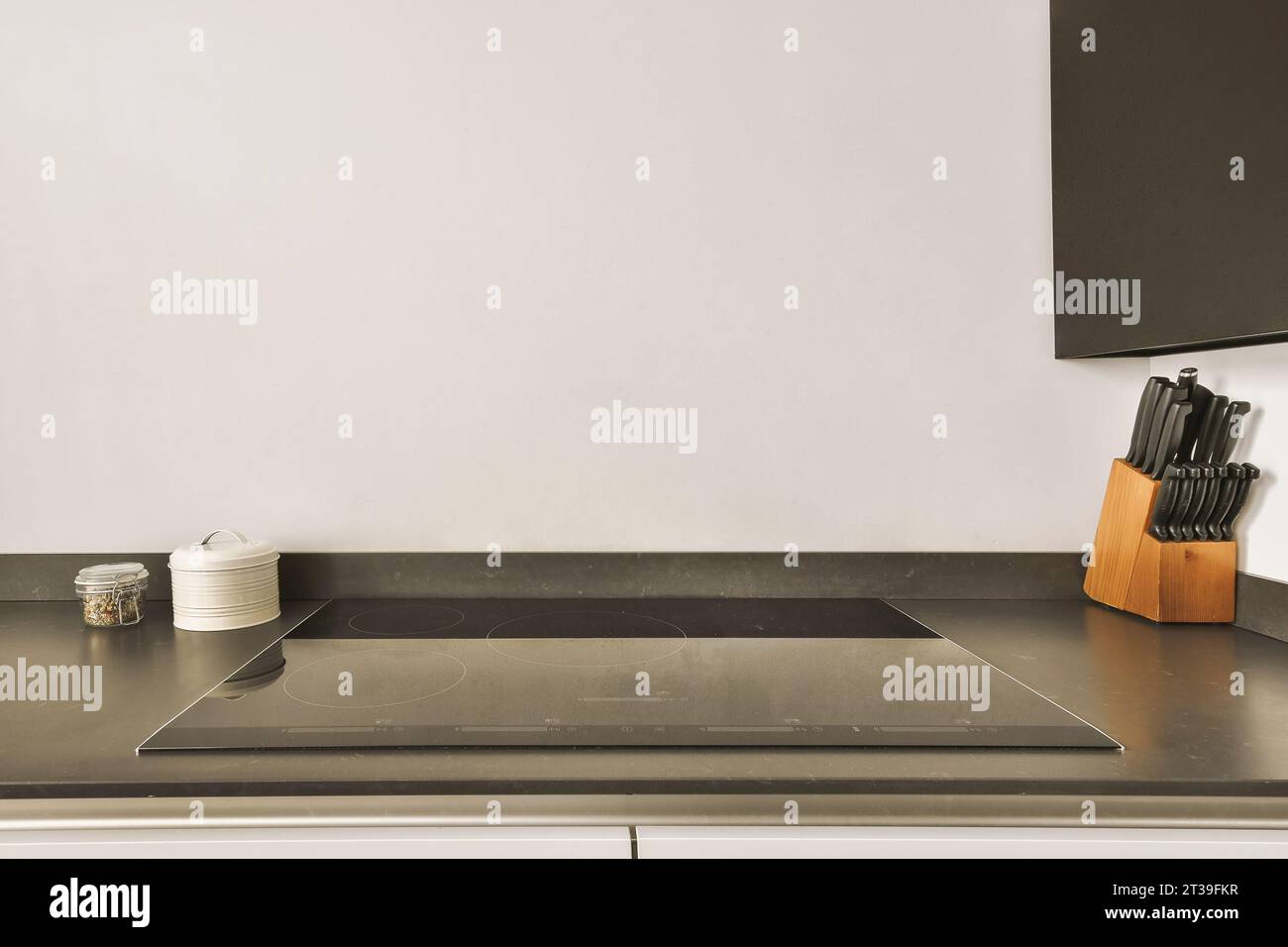 Black induction with knives in rack on clean countertop in modern ...