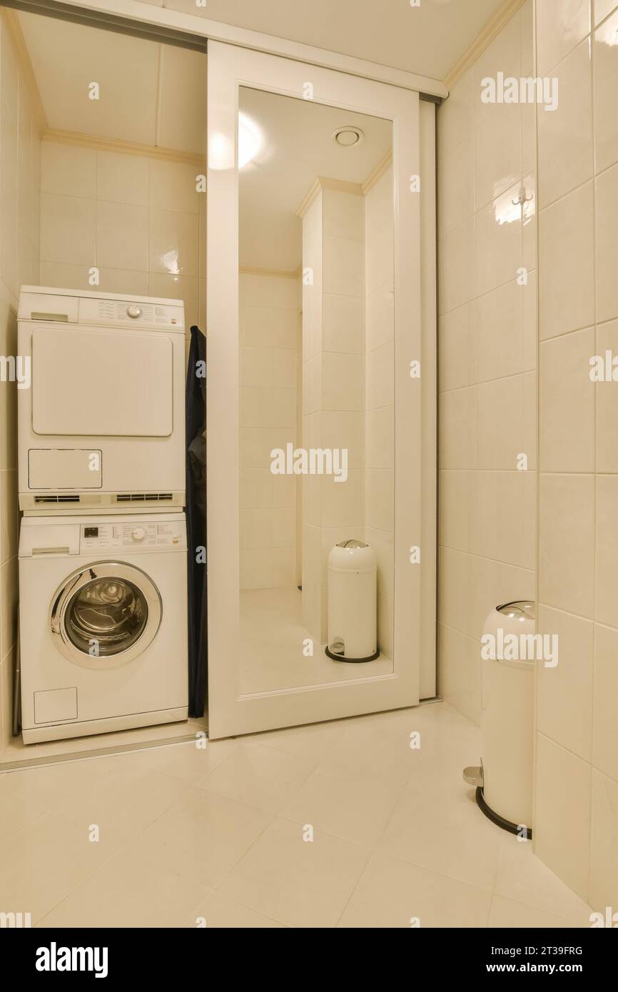 Washer and dryer machines by shower cabin with sliding doors in modern ...