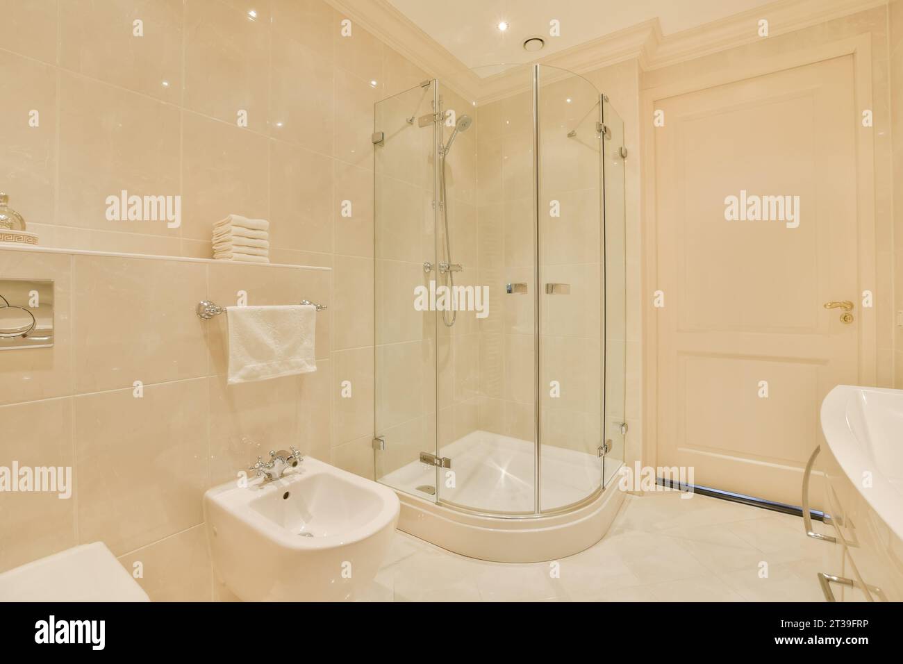 Interior of illuminated bathroom with shower cabin and toilet bowls by ...