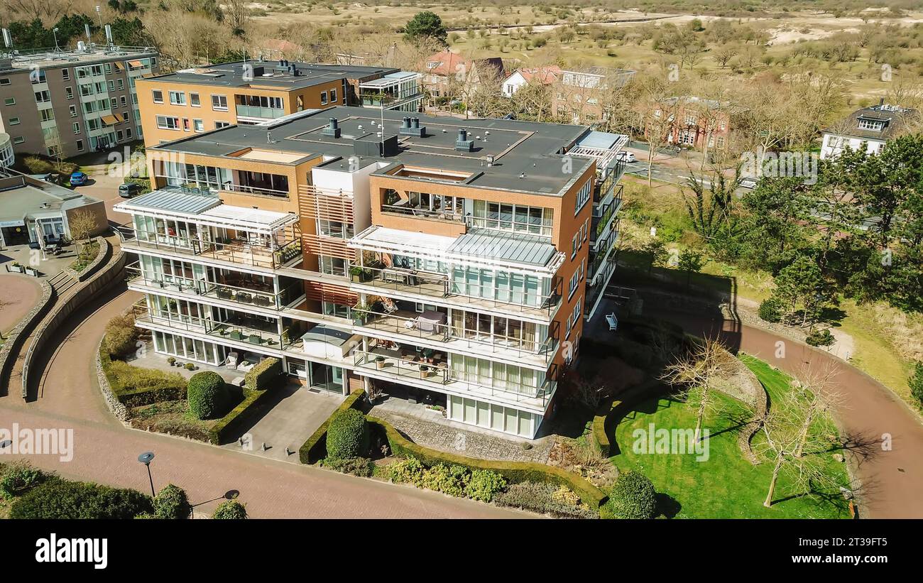 Aerial view of modern apartment building with balconies and garden in ...