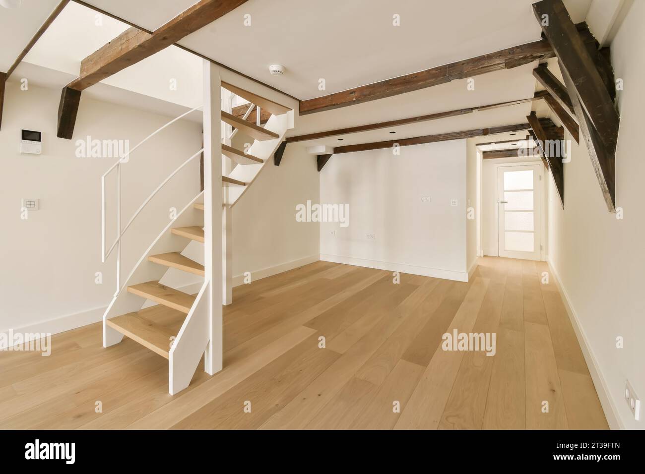 Interior of unfurnished room with wooden steps leading to upper floor ...