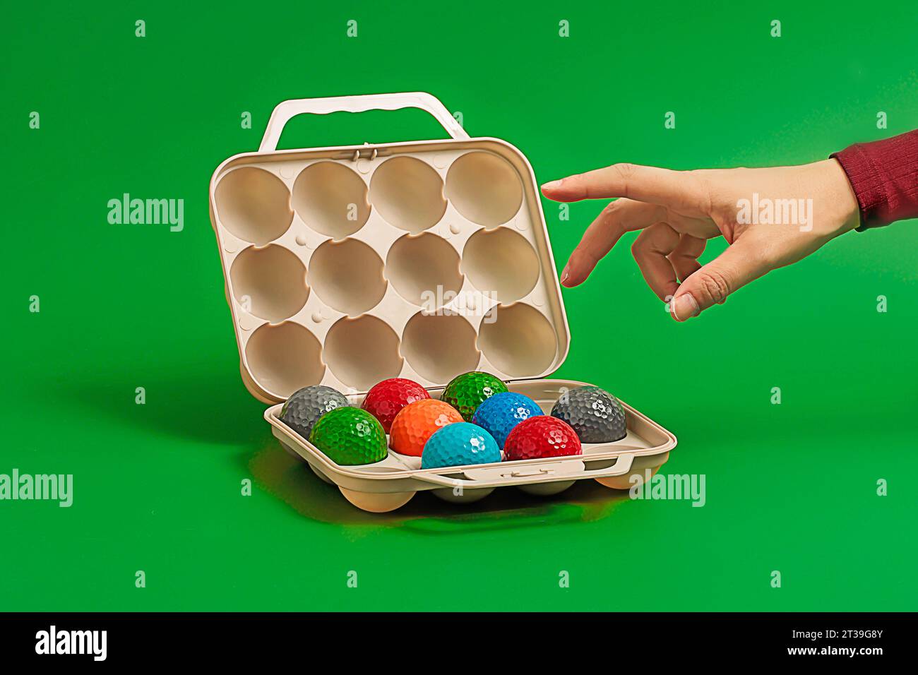 Crop unrecognizable person hand with plastic golf box with colorful ...