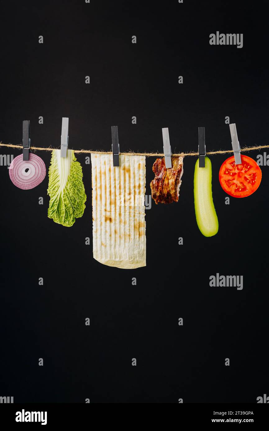 Shawarma ingredients hanging on thread in air : beef meat, lettuce ...