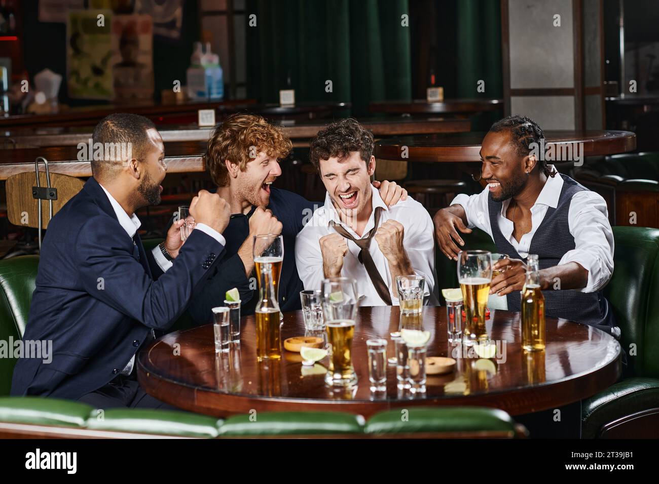 four happy and drunk interracial colleagues having fun after work in ...