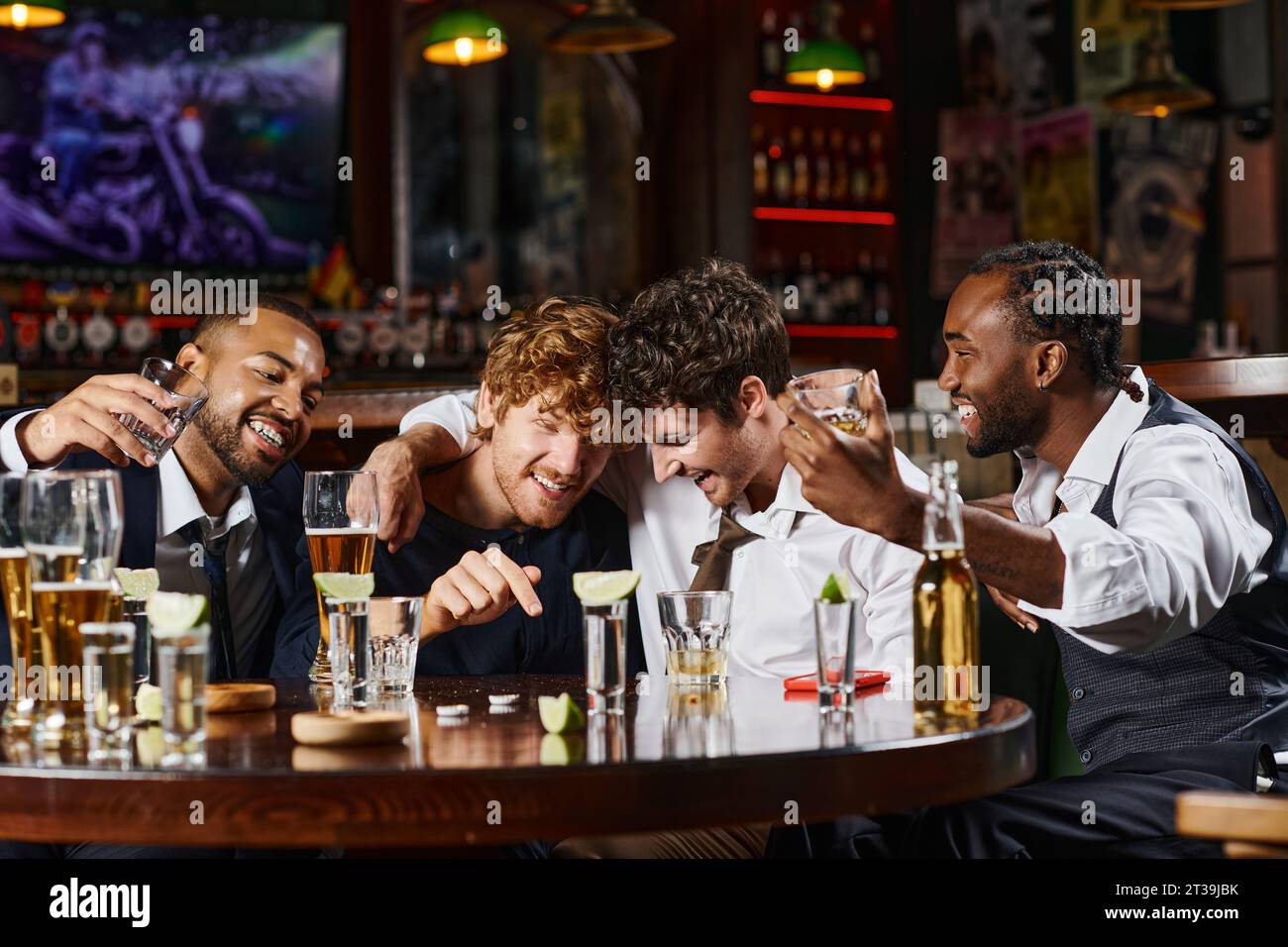 happy and drunk multiethnic friends hugging during bachelor party in ...