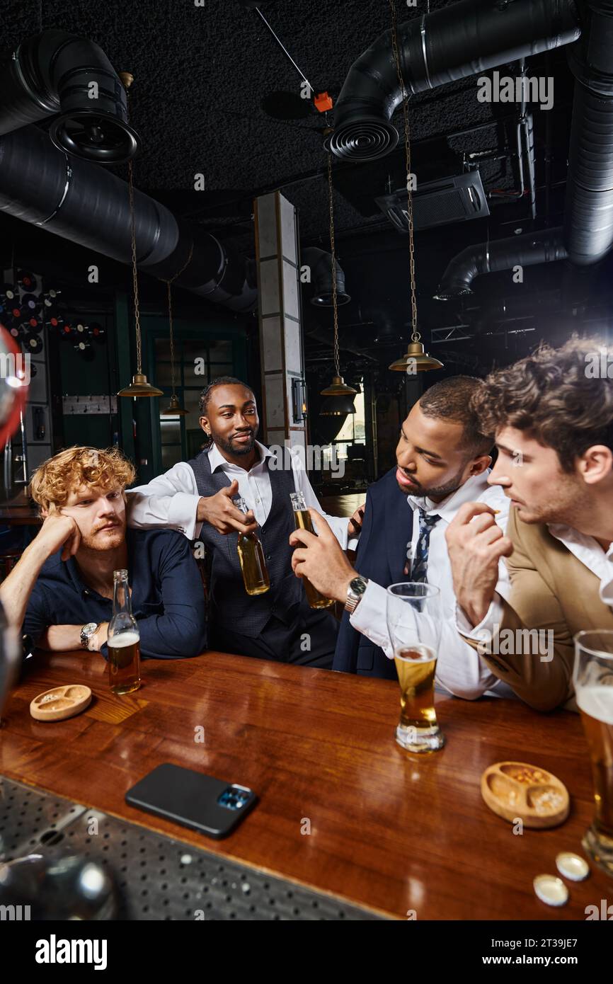 drunk colleagues in formal wear chatting and drinking beer in bar ...