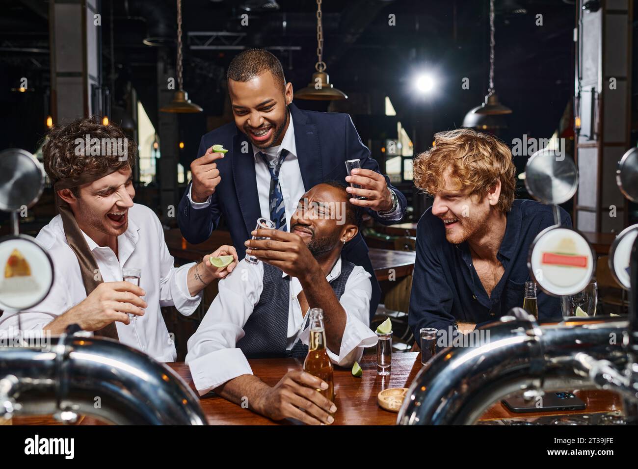 group of four happy and drunk multiethnic friends in formal wear ...