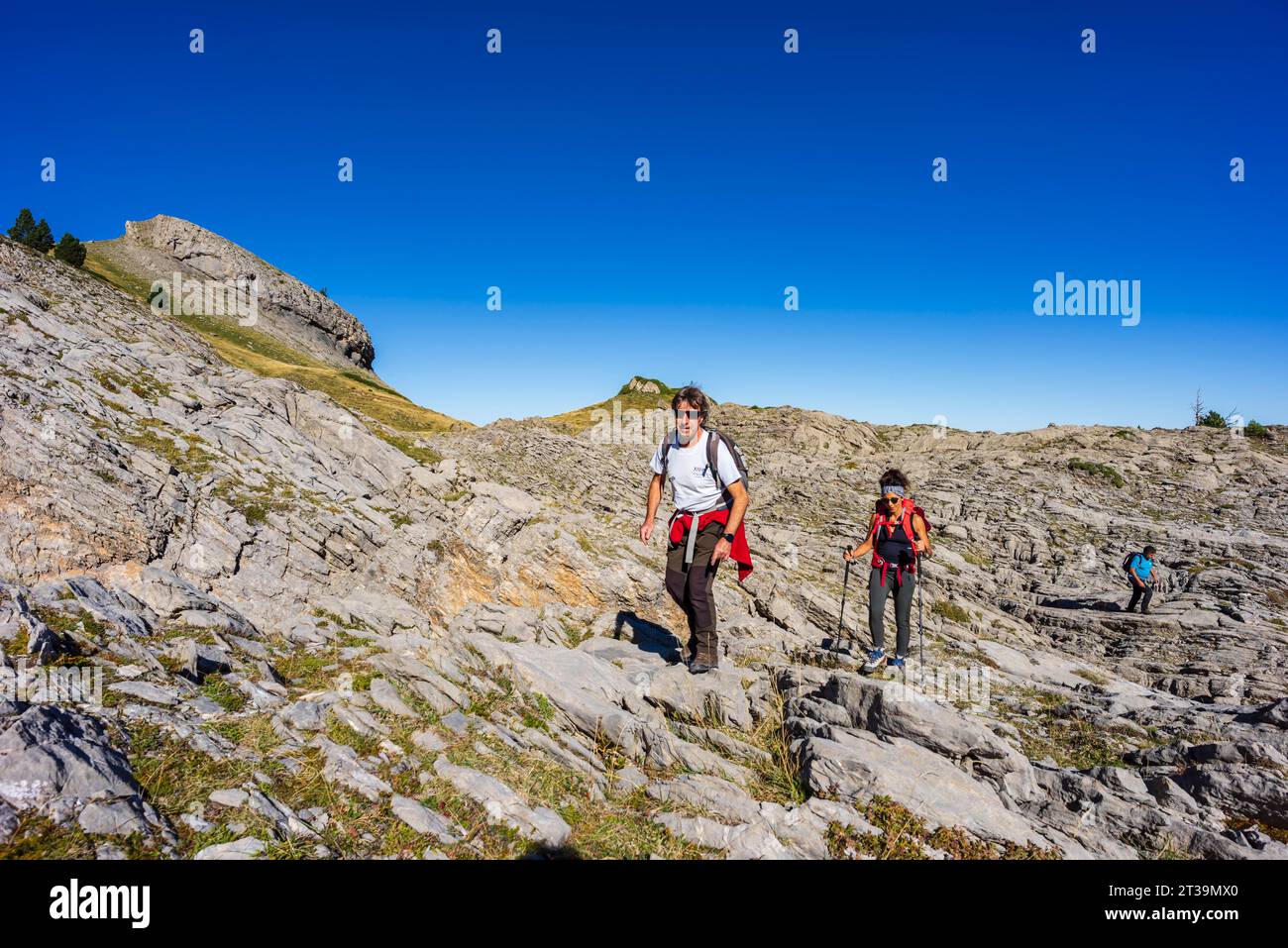 hiker advancing through the limestone relief of the Arres de Anie, Anie ...