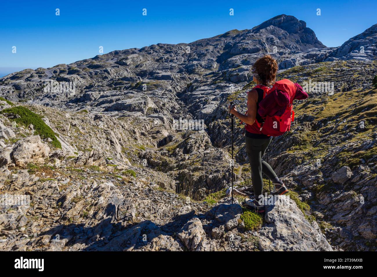 hiker advancing through the limestone relief of the Arres de Anie, Anie ...