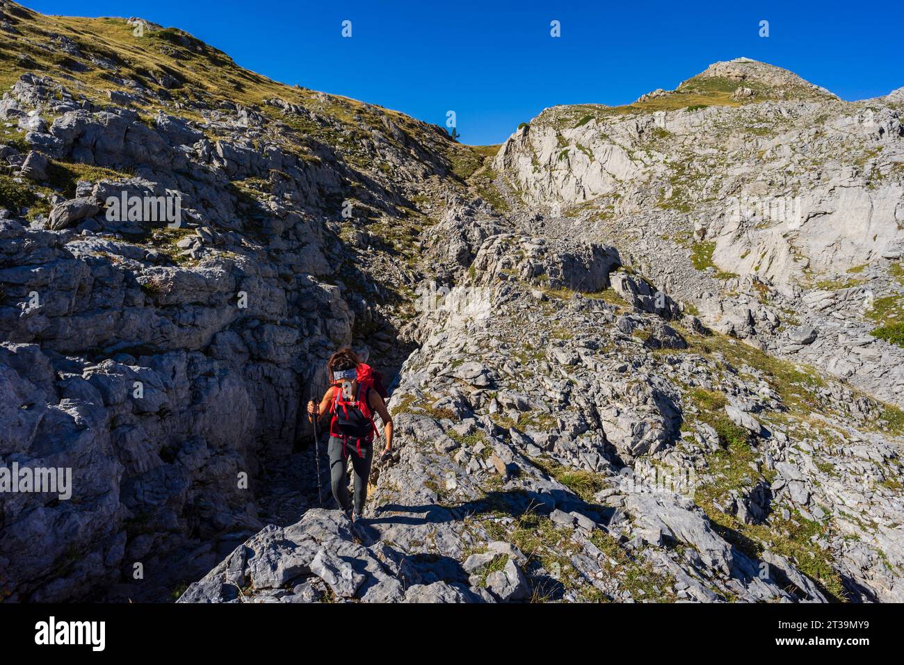 hiker advancing through the limestone relief of the Arres de Anie, Anie ...