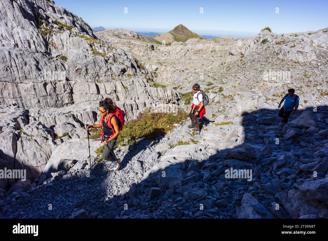 hiker advancing through the limestone relief of the Arres de Anie, Anie ...