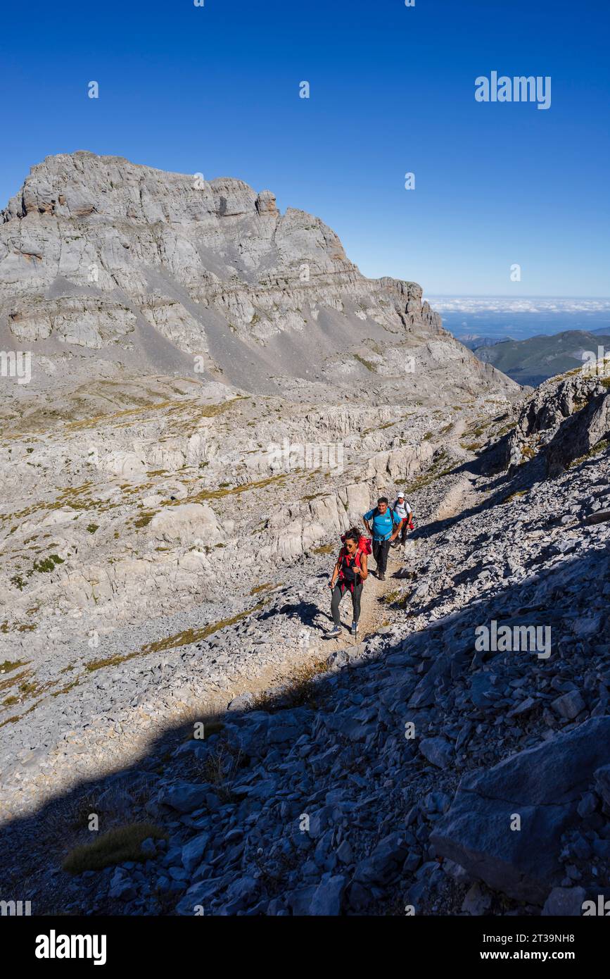 hiker advancing through the limestone relief of the Arres de Anie, Anie ...