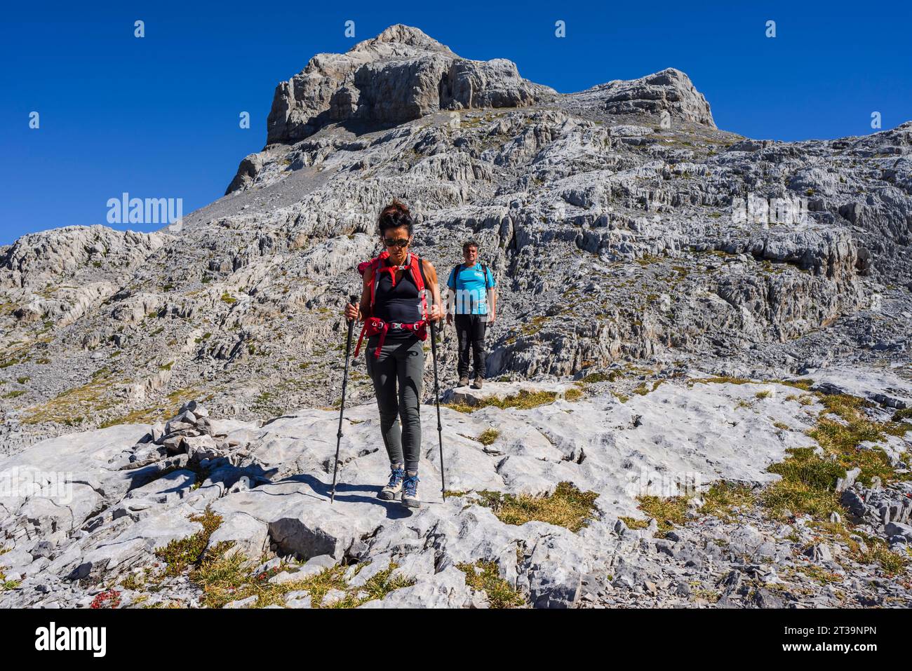 hiker advancing through the limestone relief of the Arres de Anie, Anie ...
