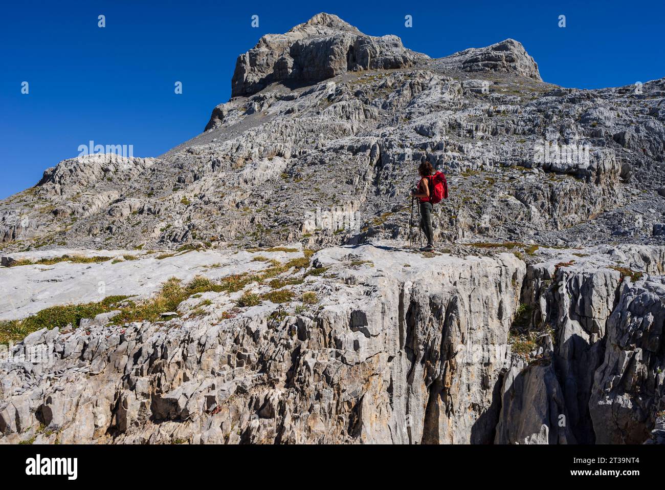 hiker advancing through the limestone relief of the Arres de Anie, Anie ...