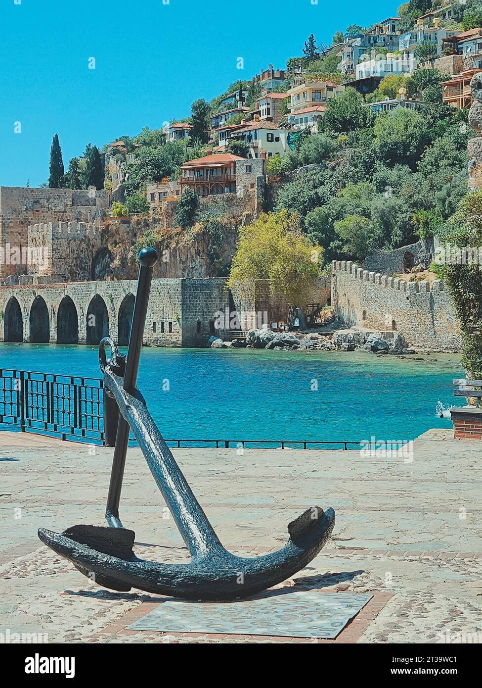 statue of an anchor against the backdrop of the blue sea, mountains and ...