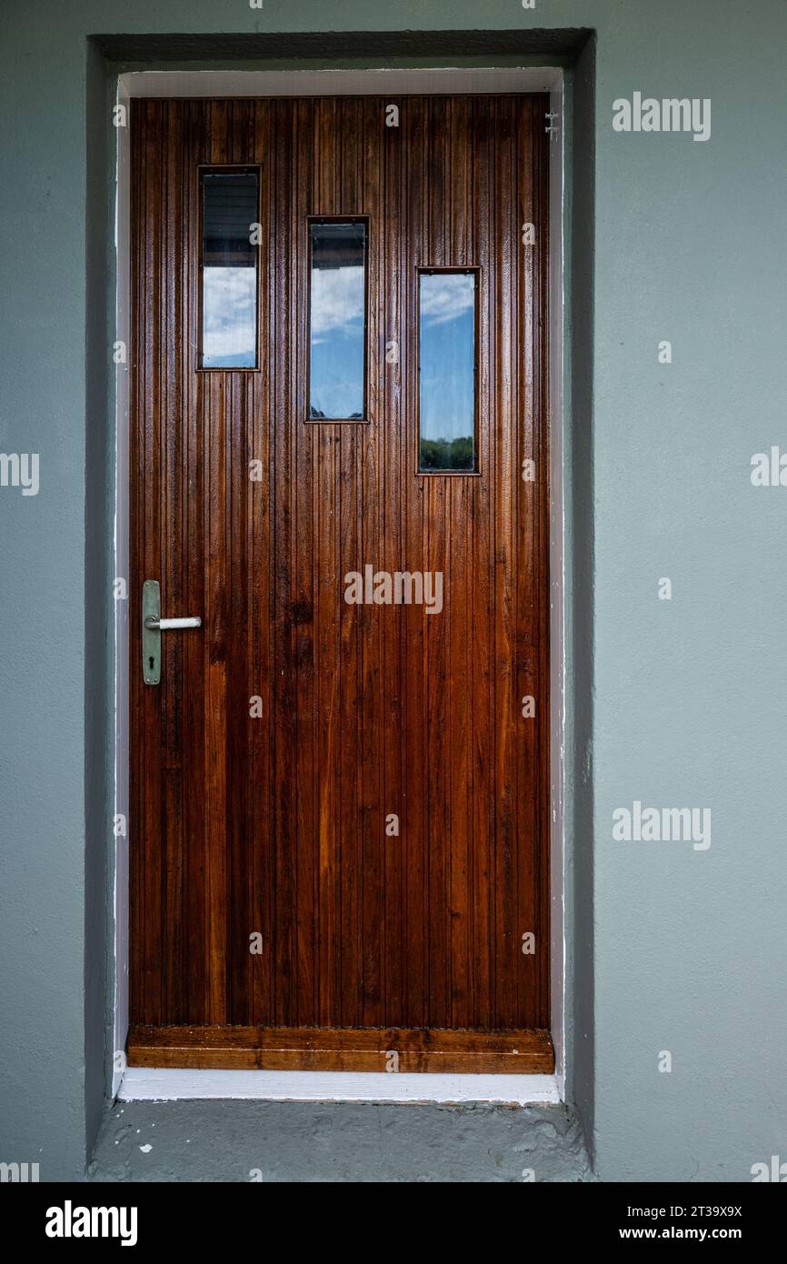 Classic wooden teak door with tree windows Stock Photo - Alamy