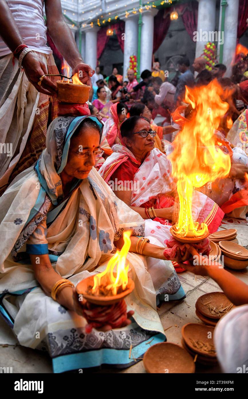 Kolkata, India. 22nd Oct, 2023. An Indian Hindu woman sits with burning ...