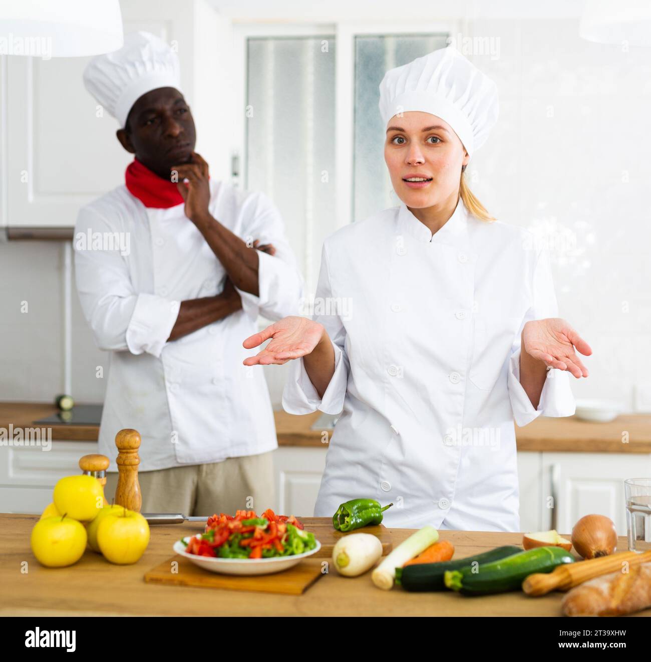 Chefs in white uniform having conflict on kitchen Stock Photo - Alamy