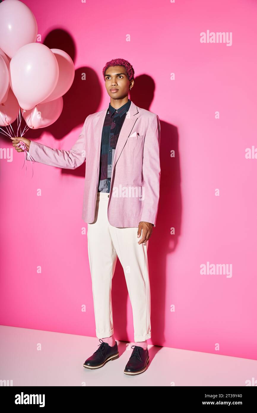 stylish pink haired male model standing unnaturally with balloons in ...
