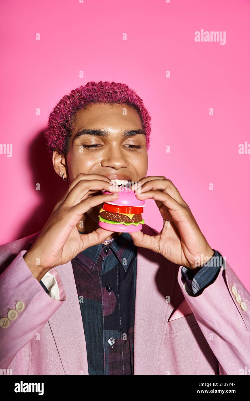 good looking stylish male model with curly hair eating delicious mini ...