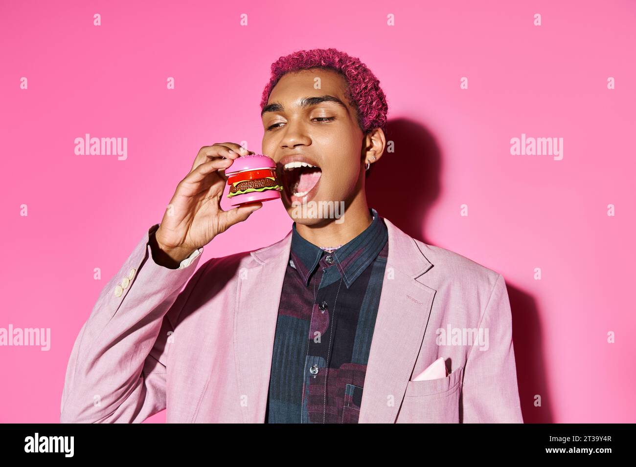 stylish african american man with silver earrings eating mini burger ...
