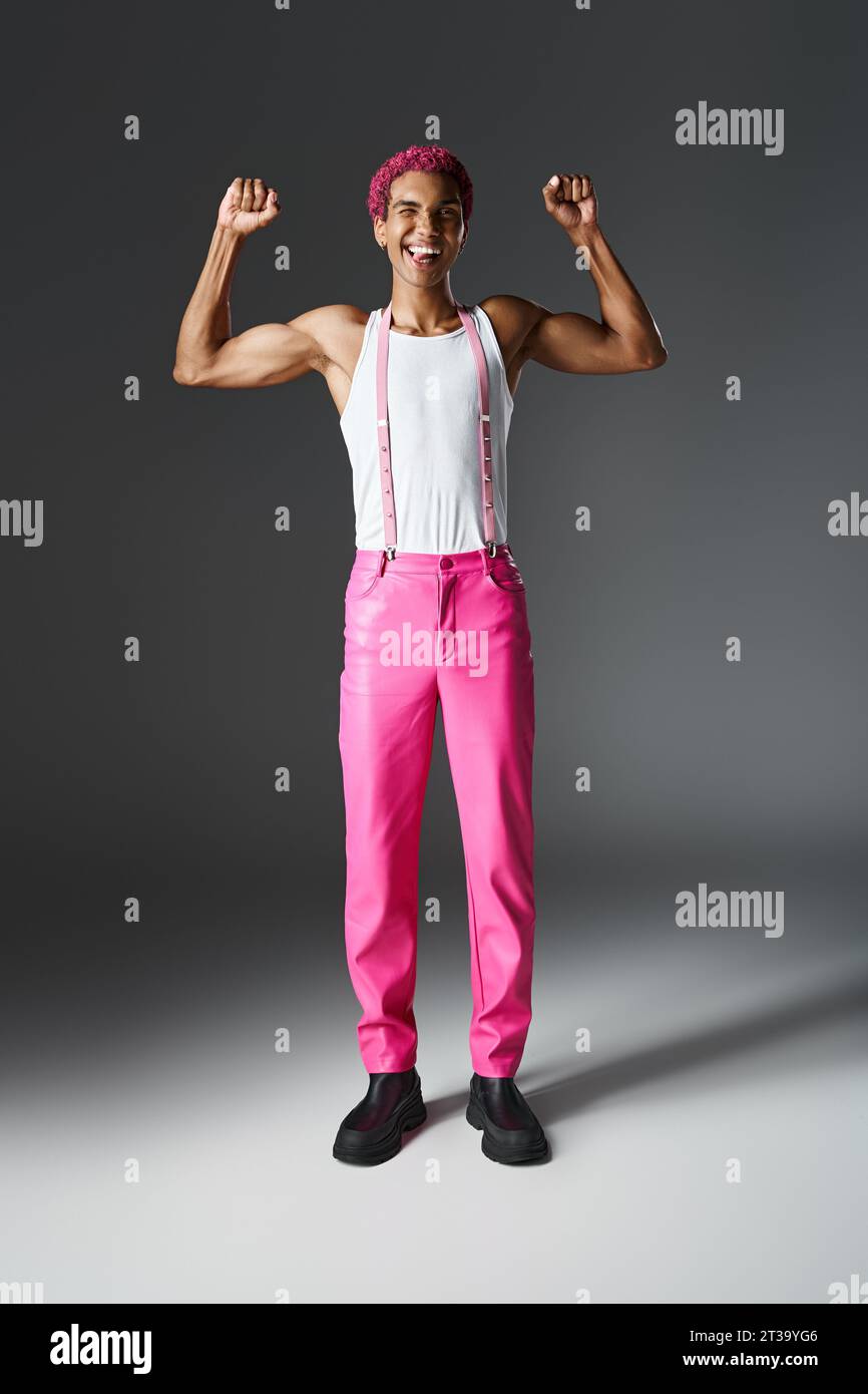 playful young male model with pink hair showing muscles and smiling at ...