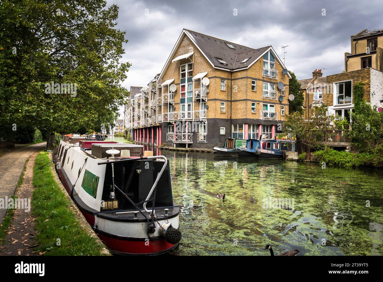 Narrowboats and social housing buildings along Grand Union Canal ...
