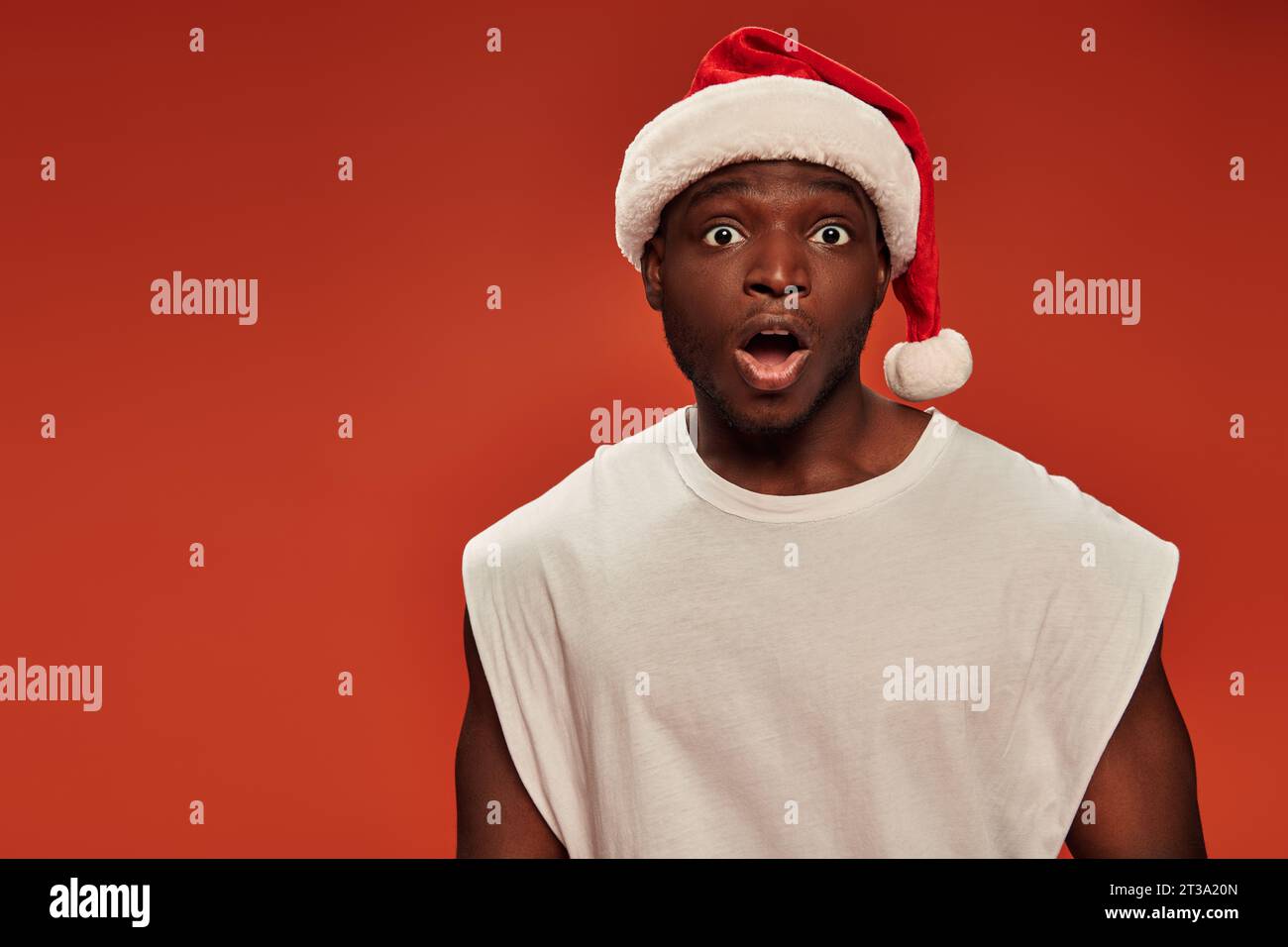 shocked african american guy in santa hat looking at camera with open ...