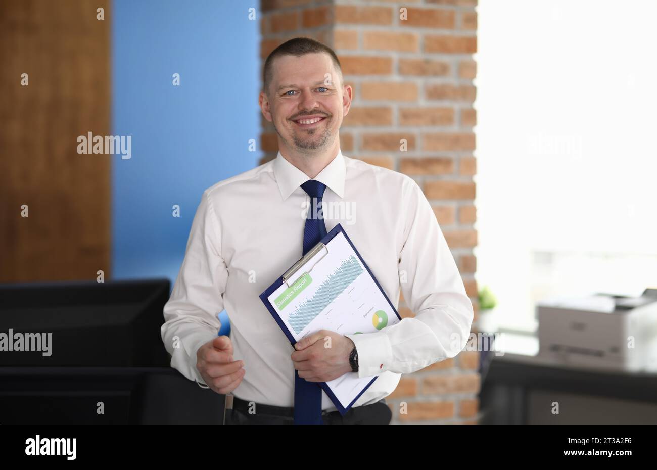 Businessman smiles and holds charts with business figures. Business ...