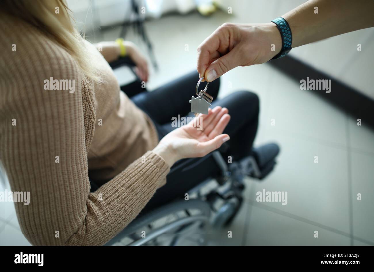 Woman is sitting in wheelchair and keys are handed over to her. Getting ...