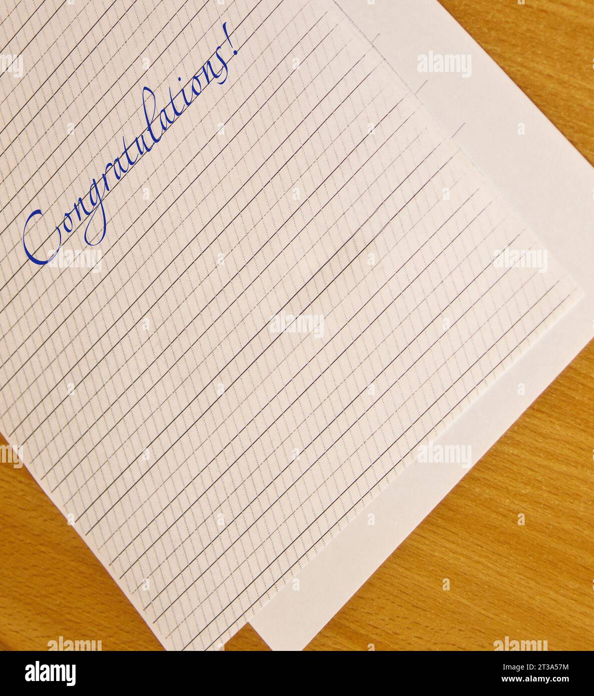 word congratulations is written with ink pen on a white paper sheet ...