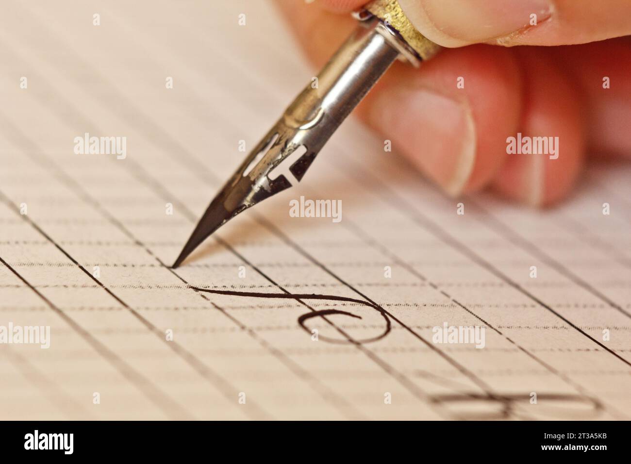 female hand writes with the inky pen on a white paper sheet with ...