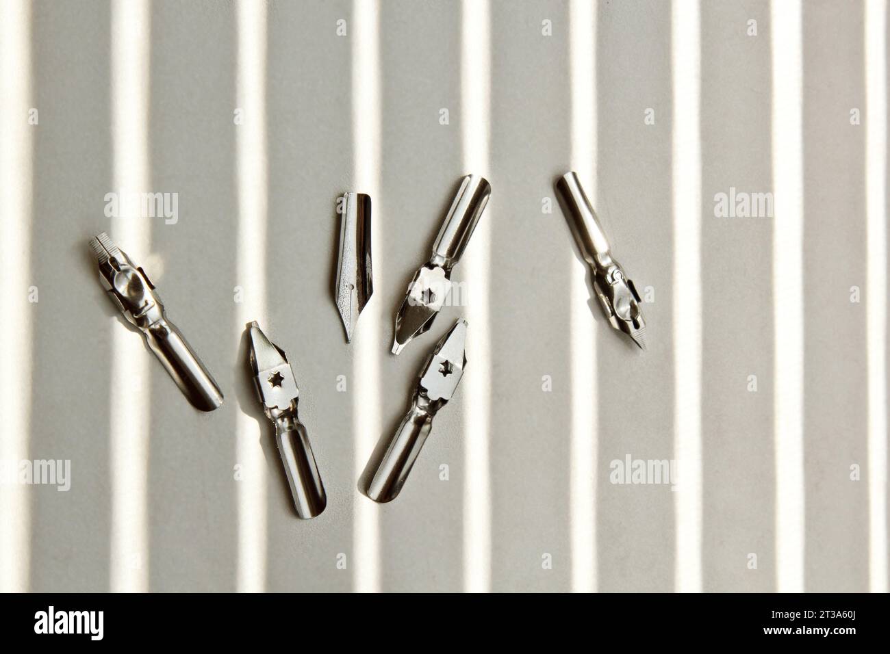 metal tips for the ink pen on a white background in solar rays ...