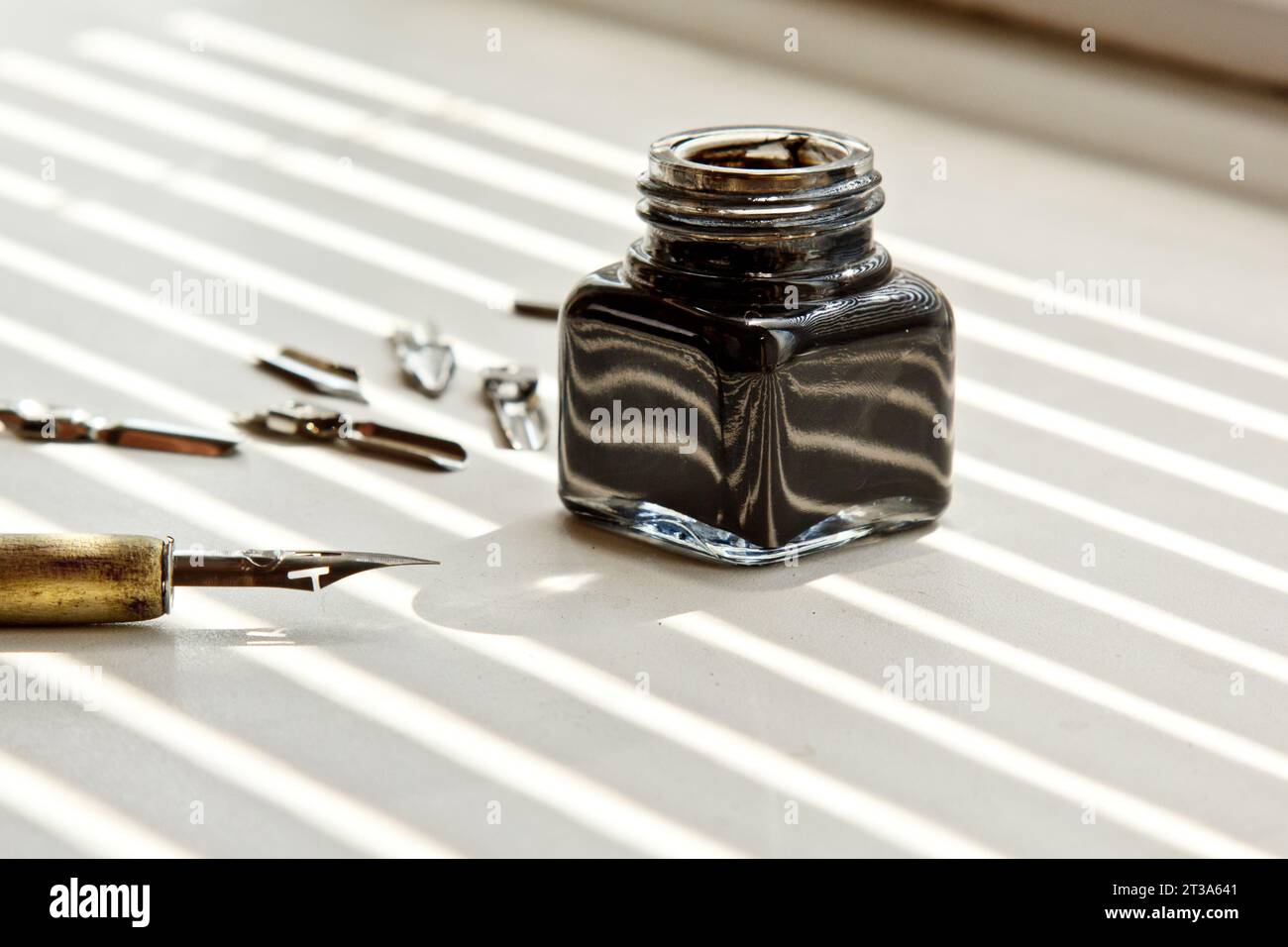 Inkpot with metal tips for the ink pen on a white background in solar ...