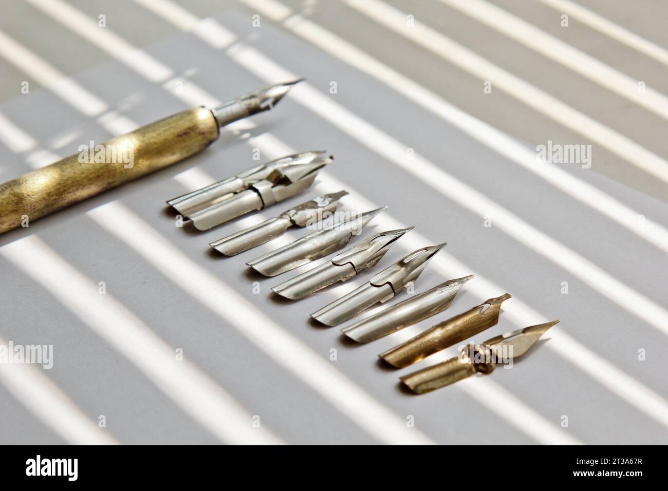 metal tips for the ink pen on a white background in solar rays ...