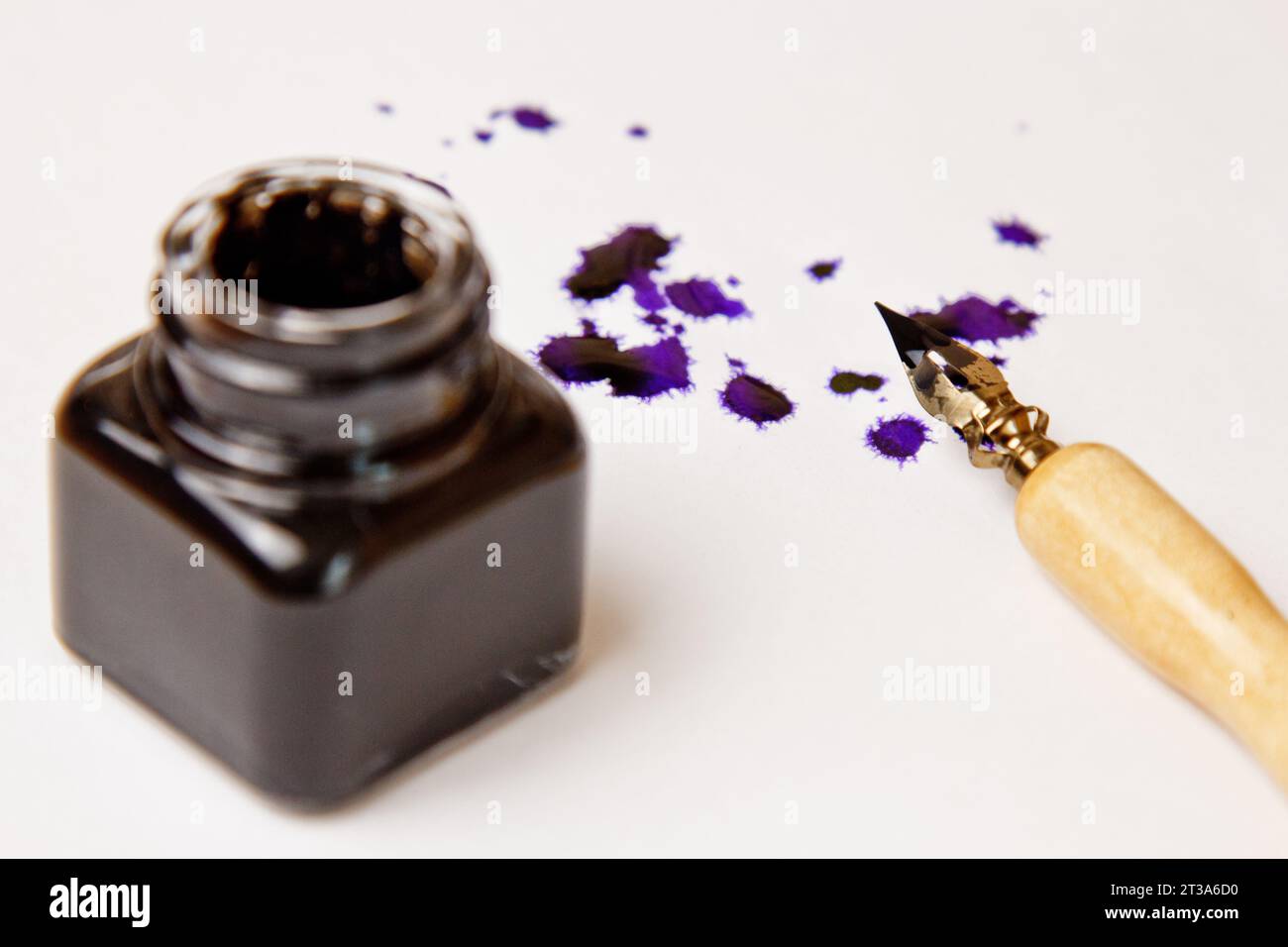 ink stain drawn with an ink pen on a white paper sheet with inkwell ...