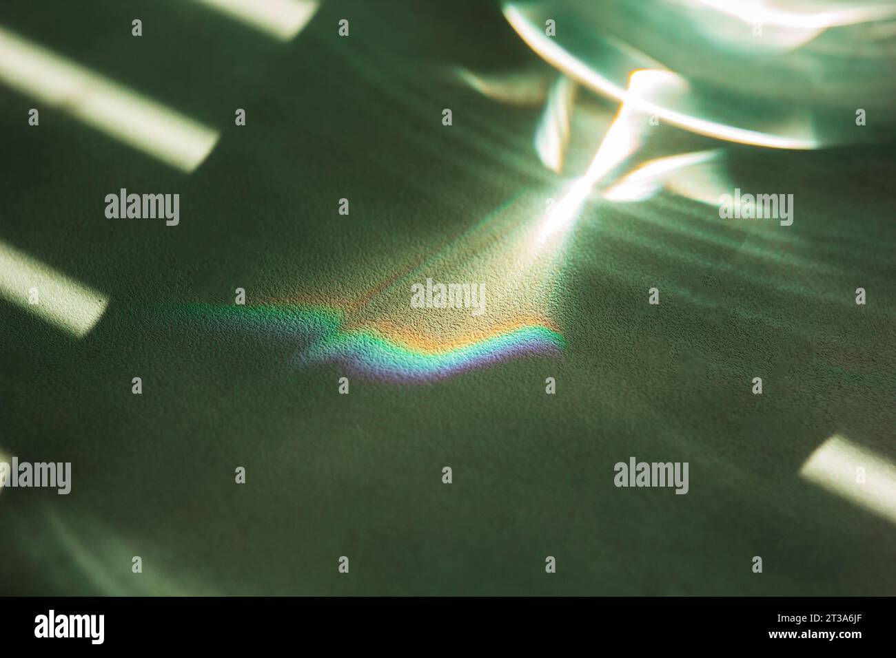 reflection of sunlight through a glass of water on a white table. the ...