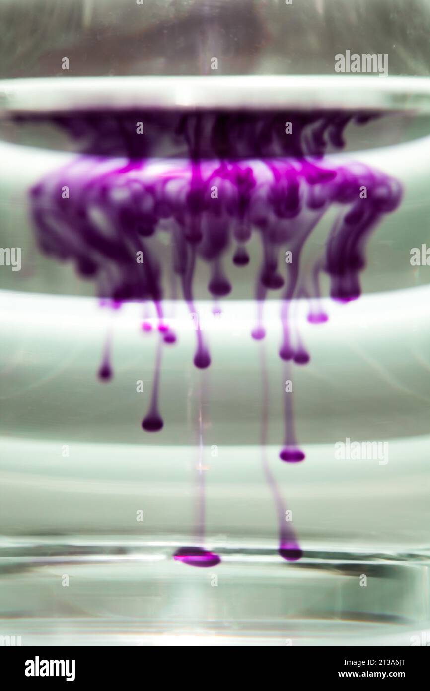 diffusion of blue ink in a transparent glass cup with clear water ...