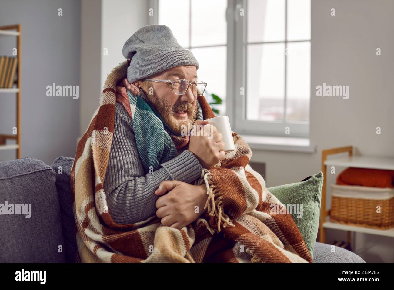 Sick elderly man with glasses feels unwell, chills and drinks medicine ...