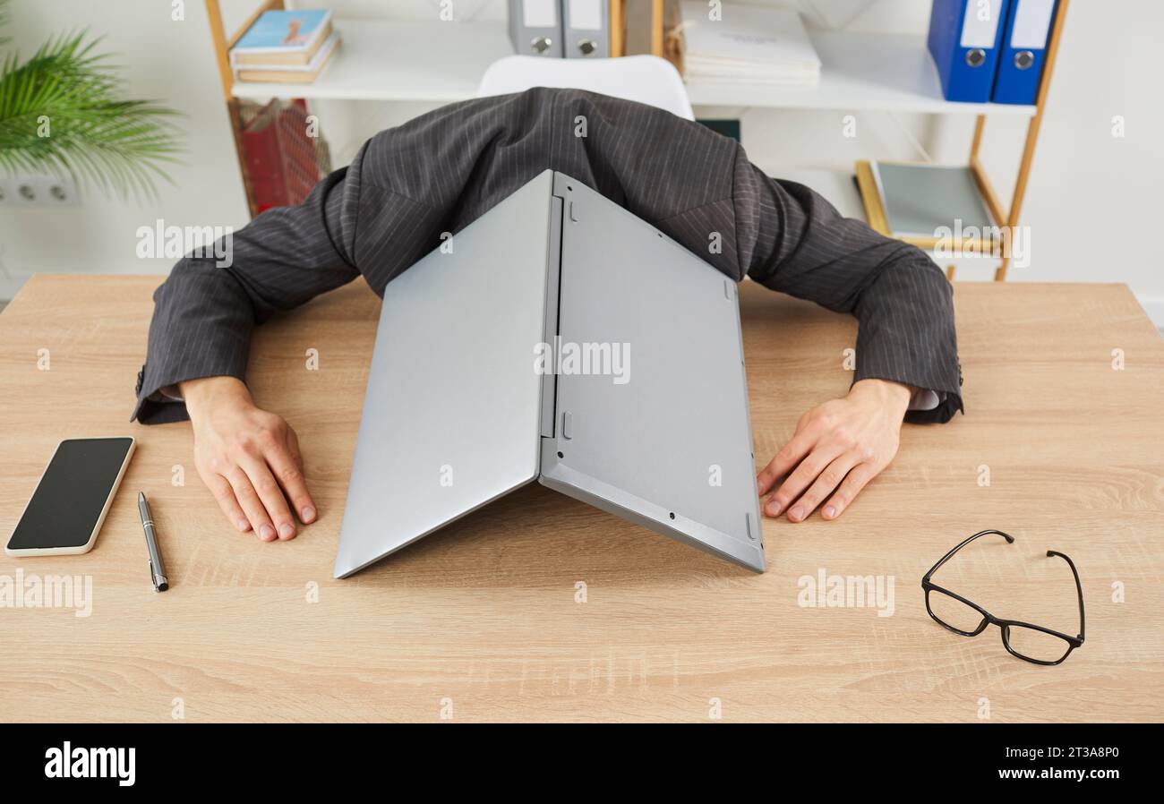Exhausted corporate employee sleeping at office desk with his head ...