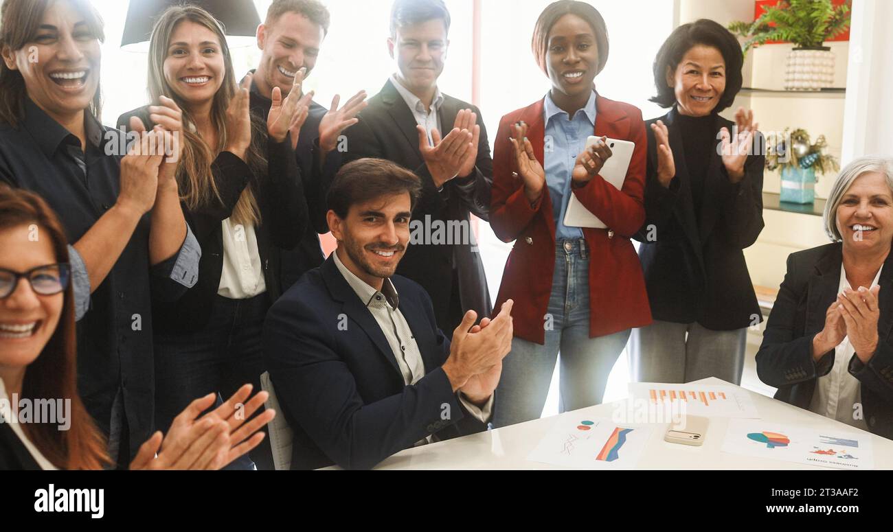 Multigenerational colleagues smiling in front of camera inside business ...