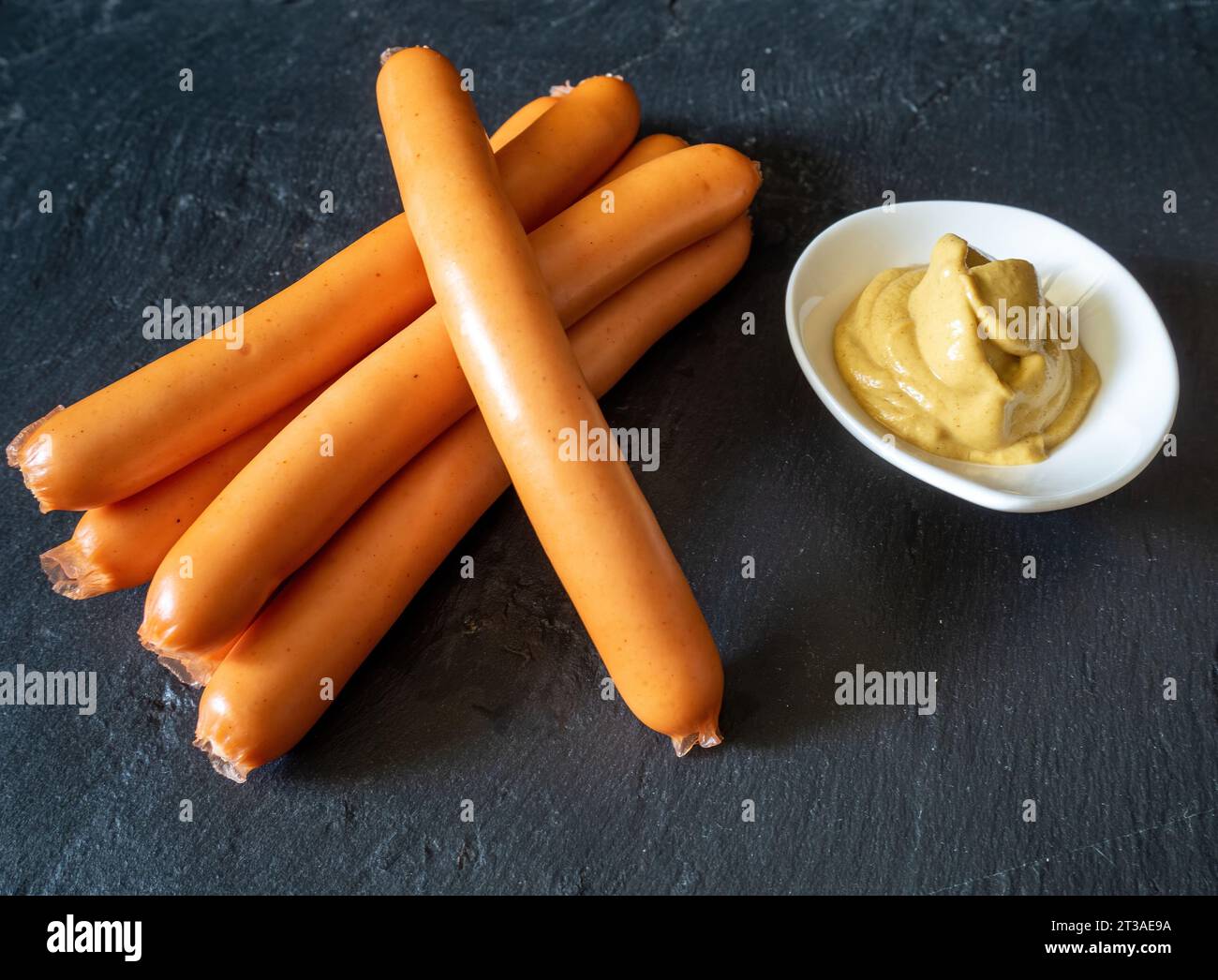 Table set with hot dog sticks and a souse on a dark atbletop Stock ...