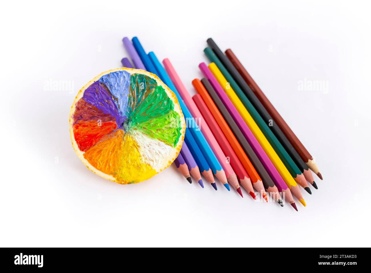 Rainbow colors painted orange fruit half next to multicolored crayons ...