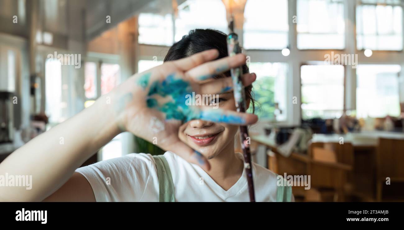 The artist creates a frame with his hands soiled with poster color ...